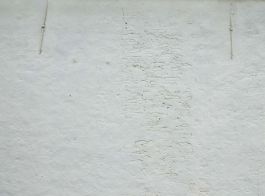 Muur met wit stucwerk en muurankers - Fotobehang